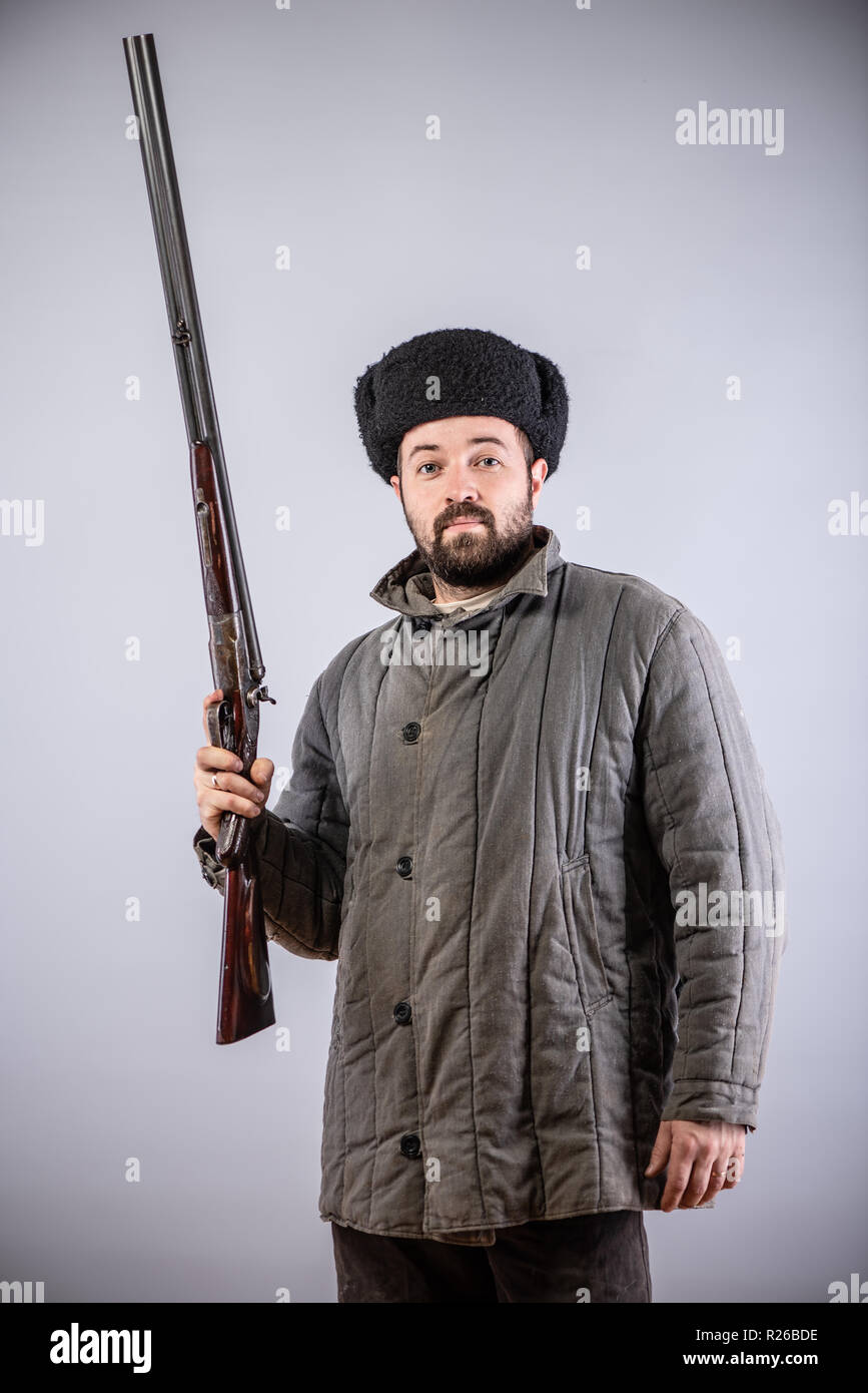 Hunter with horizontal double-barreled shotgun in hand, rifle is ...