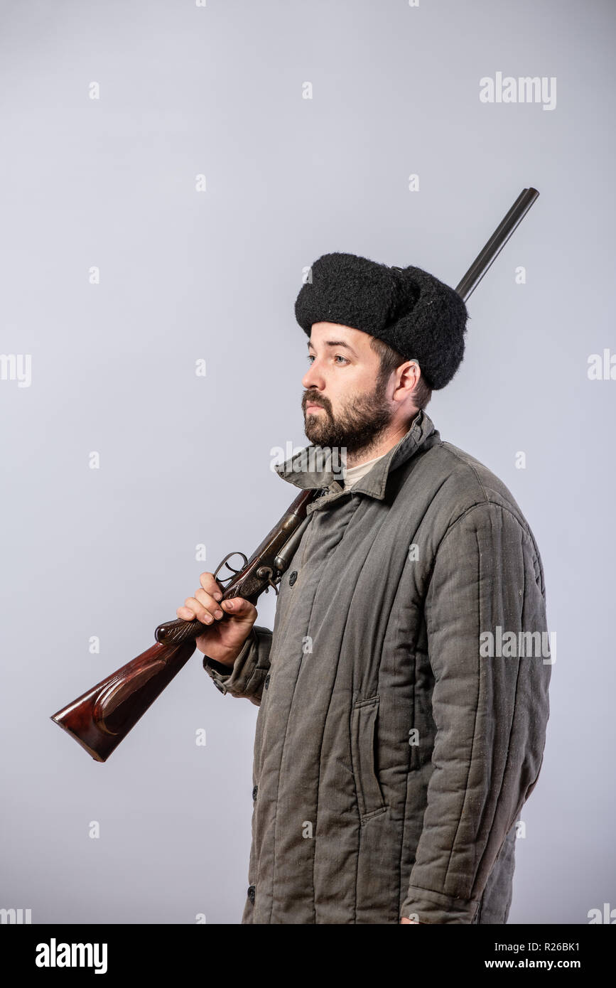 Hunter with a rifle on his shoulder, old-fashioned clothes, retro theme ...