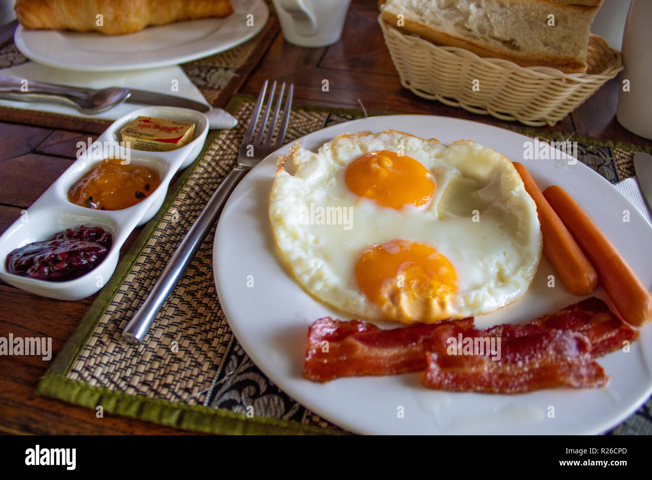 Delicious English Breakfast with fried eggs, sausages, bacon, jam and ...