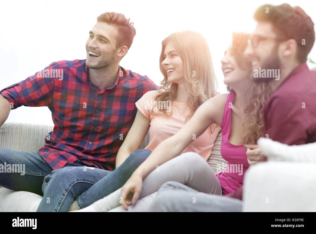 group of cheerful friends sitting on the couch Stock Photo - Alamy
