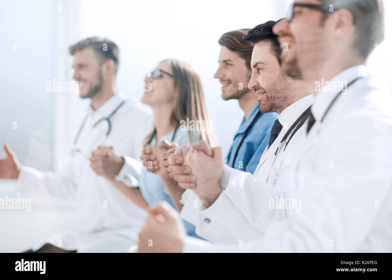 doctors sit in a row and hold hands of each other Stock Photo - Alamy