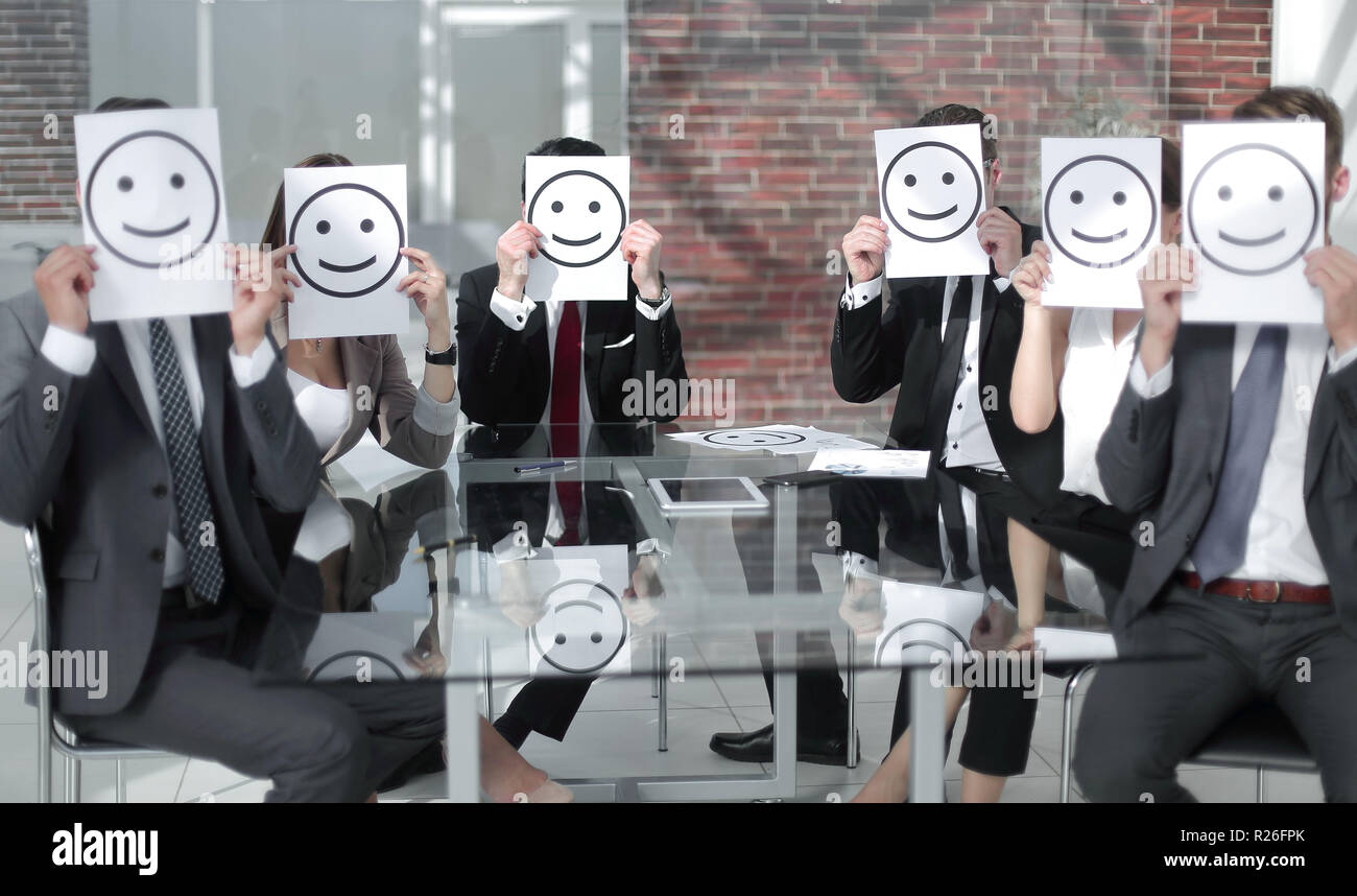 business team keeps smiley icons sitting at the Desk Stock Photo - Alamy