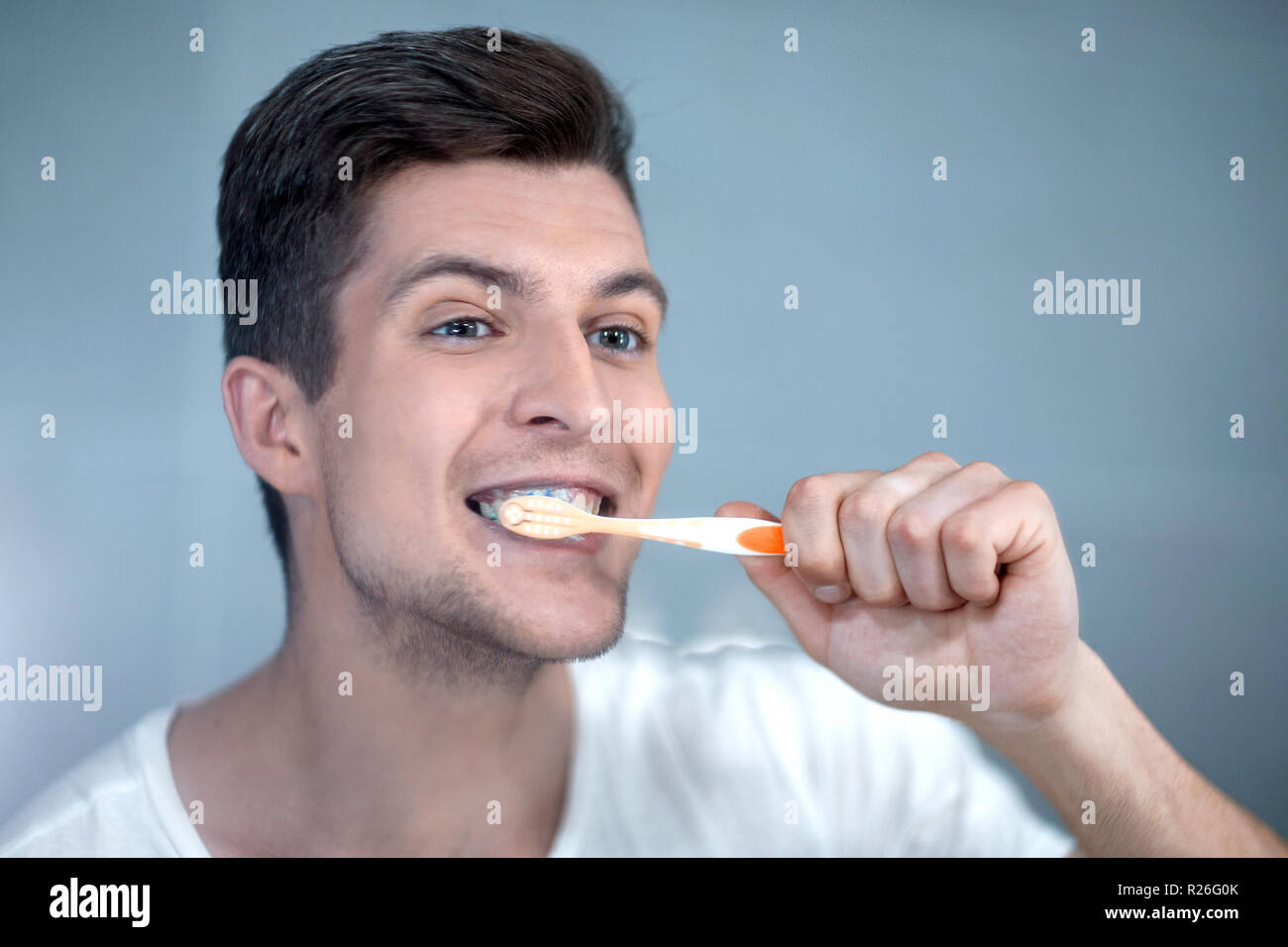 young man brushing his teeth in the bathroom Stock Photo - Alamy
