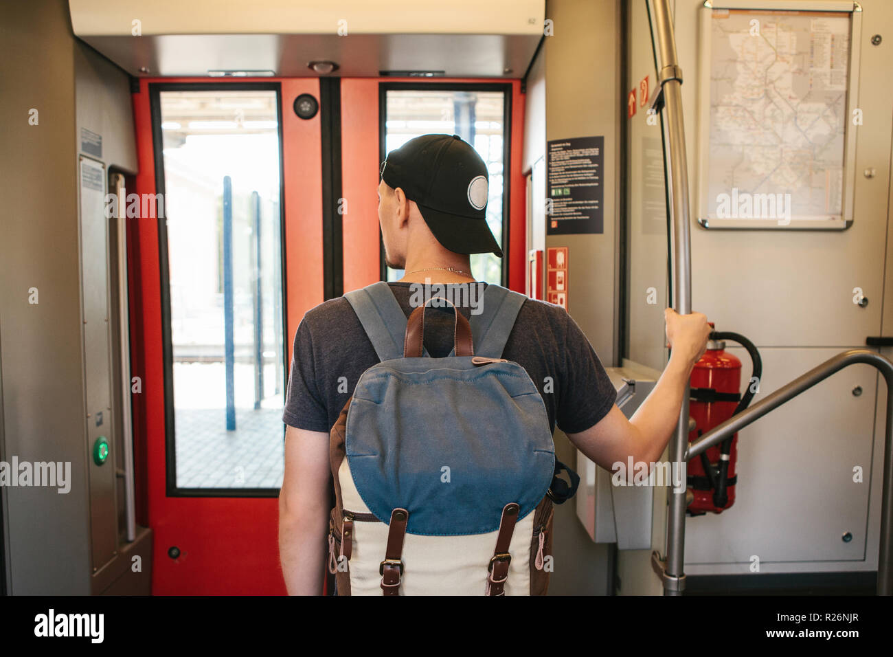 Tourist man or student with a backpack waiting for the train to stop to ...