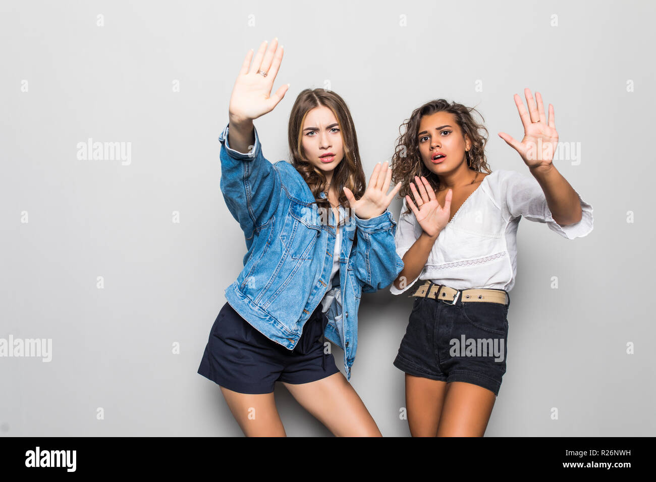 Two girls mixed race making stop sign isolated on gray background Stock ...