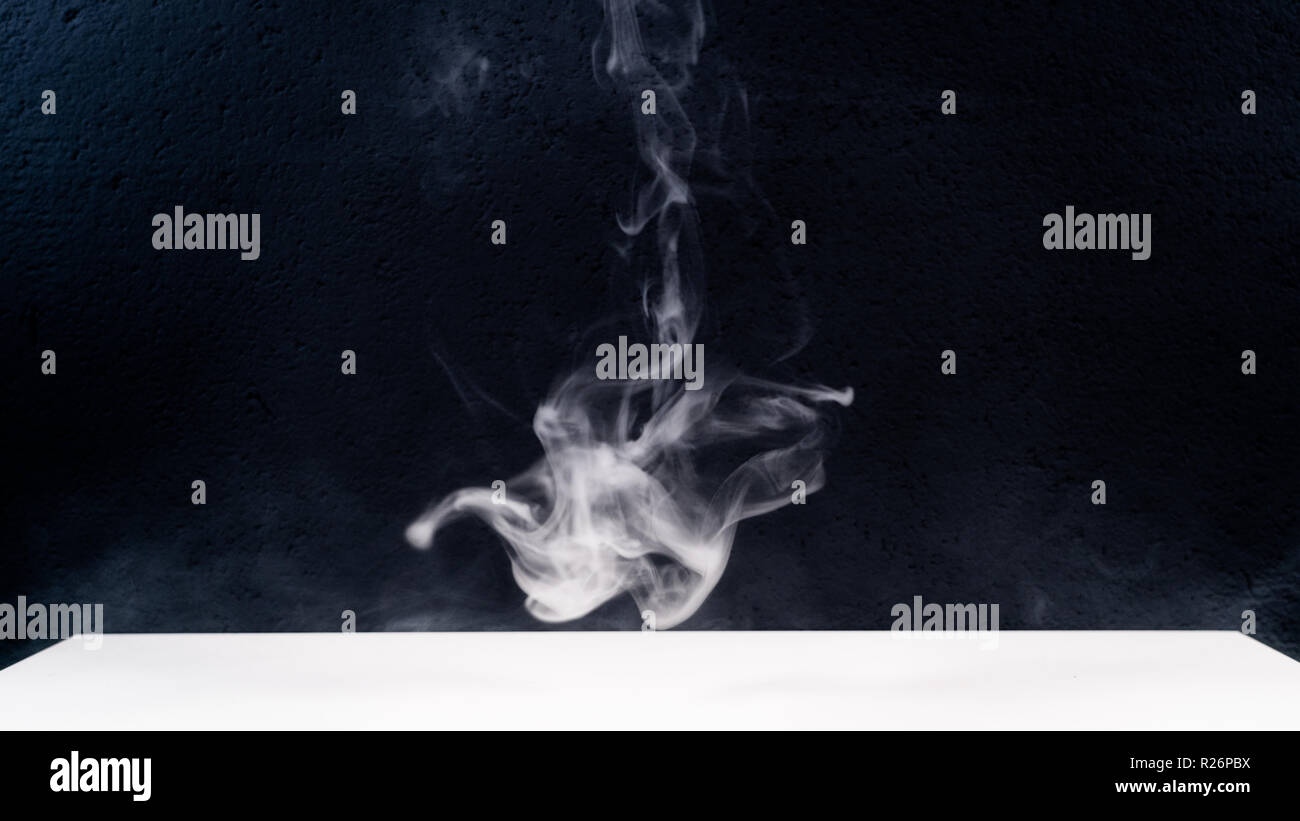 smoke falling down on a white table with a black background Stock Photo ...