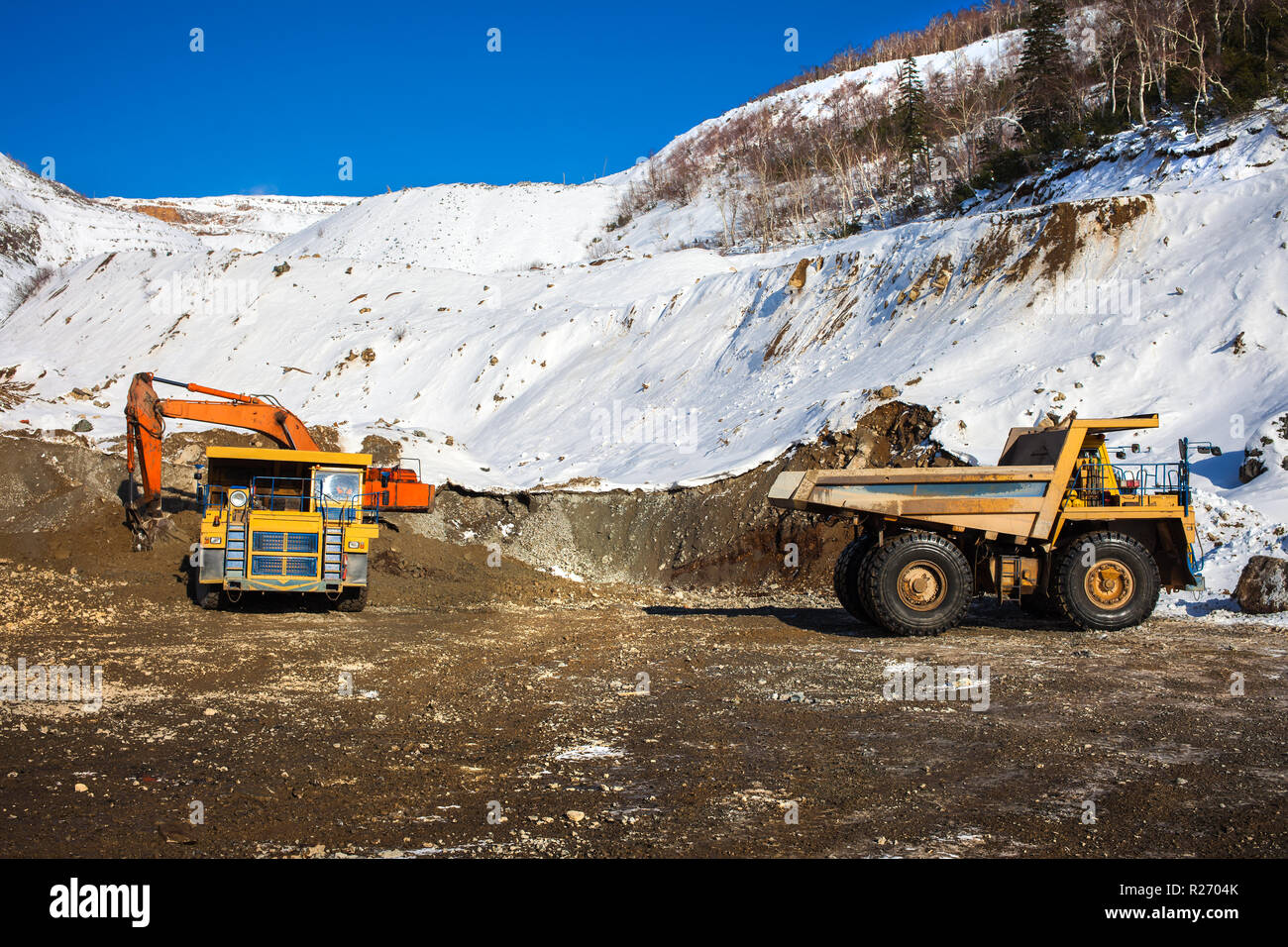 Excavator loading dump truck at gold mining Stock Photo - Alamy