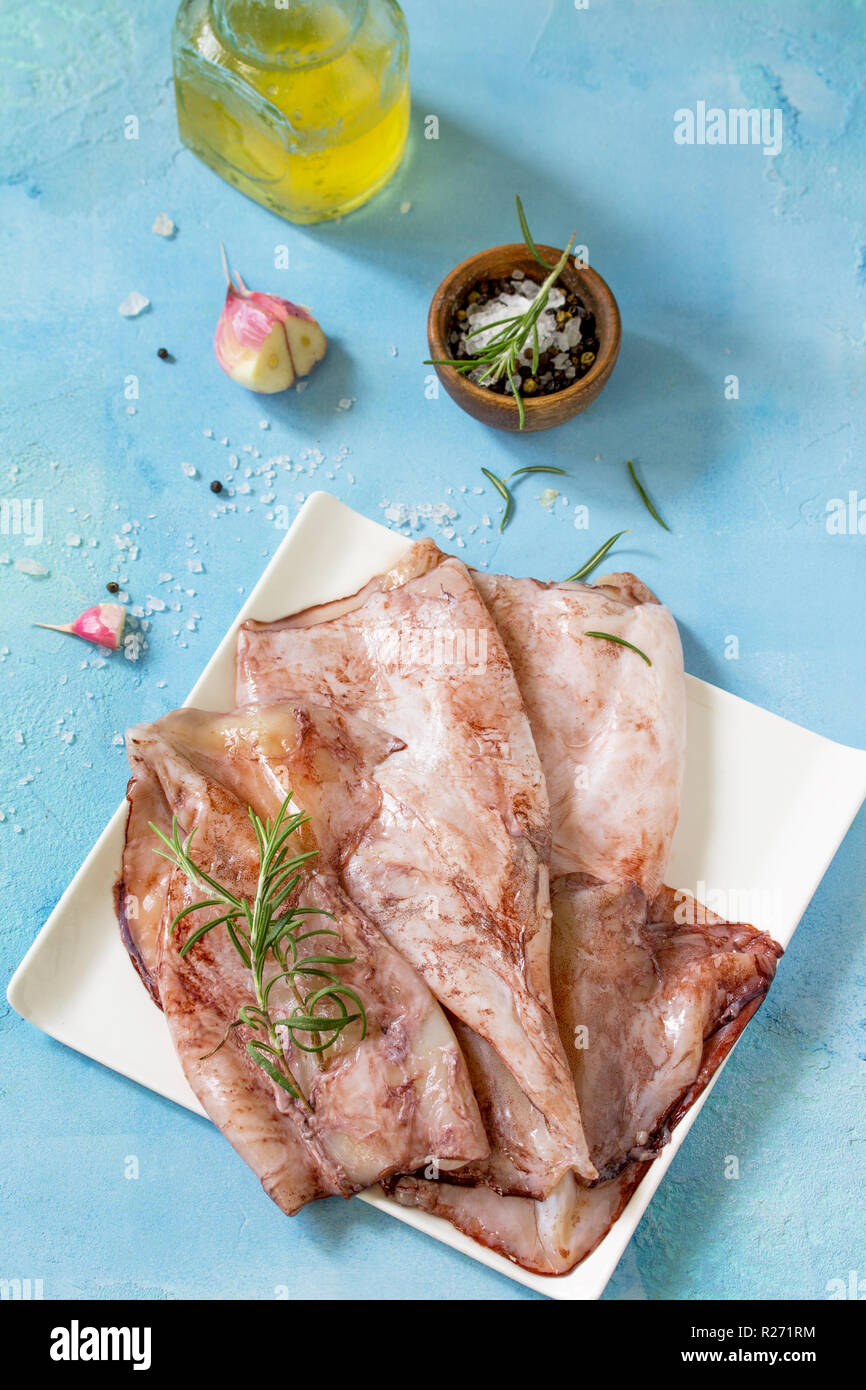 Fresh Squid, Various Spices and Olive Oil on blue concrete or stone ...