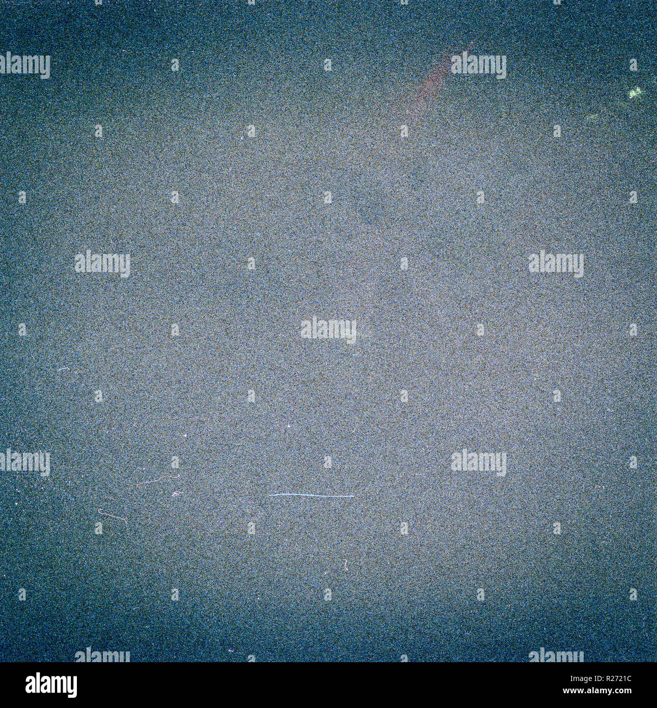Noisy blue film frame with scratches, dust and grain. Abstract old film ...