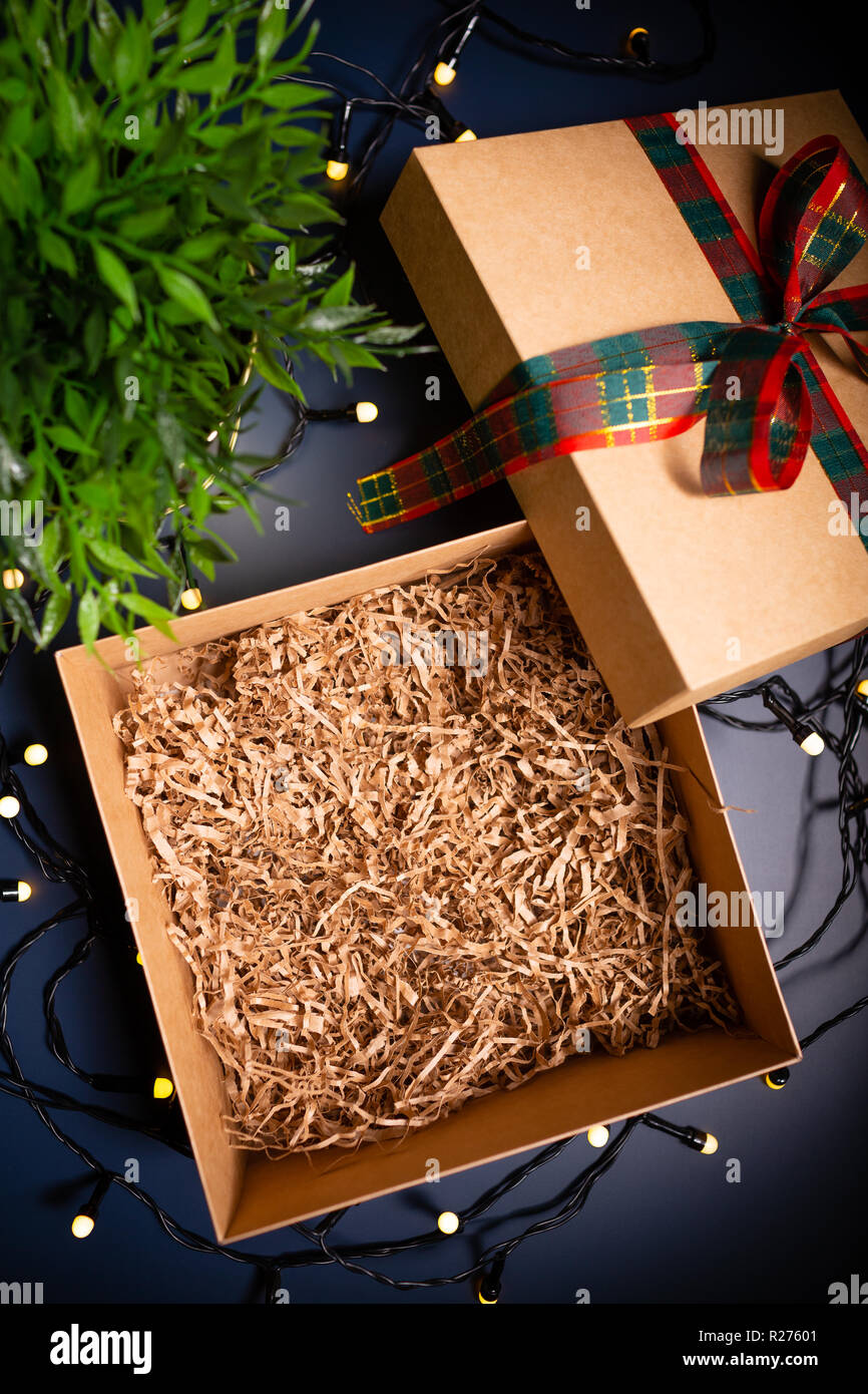 Open carton present box with ribbon on blue background surrounded by ...