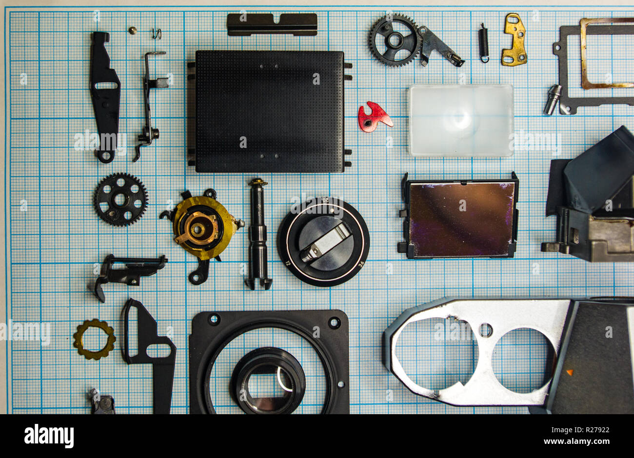 parts are completely disassembled old retro film SLR camera on graph ...