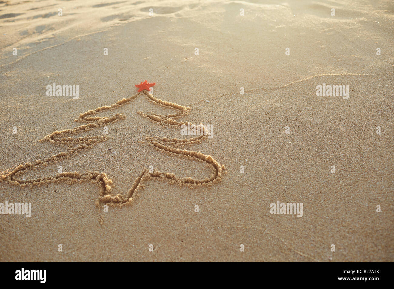 Painted Christmas tree in the sand on the beach Stock Photo - Alamy