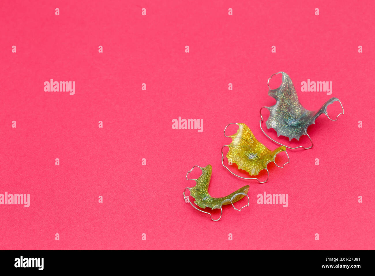 Colorful dental braces or retainers for teeth on pink background ...