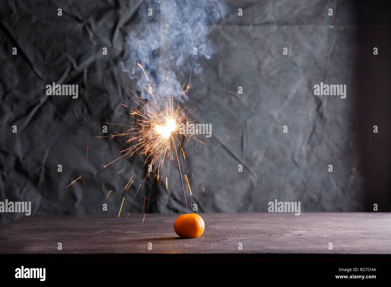 Symbols of the New Year on a dark background. Bengal fire in mandarin ...