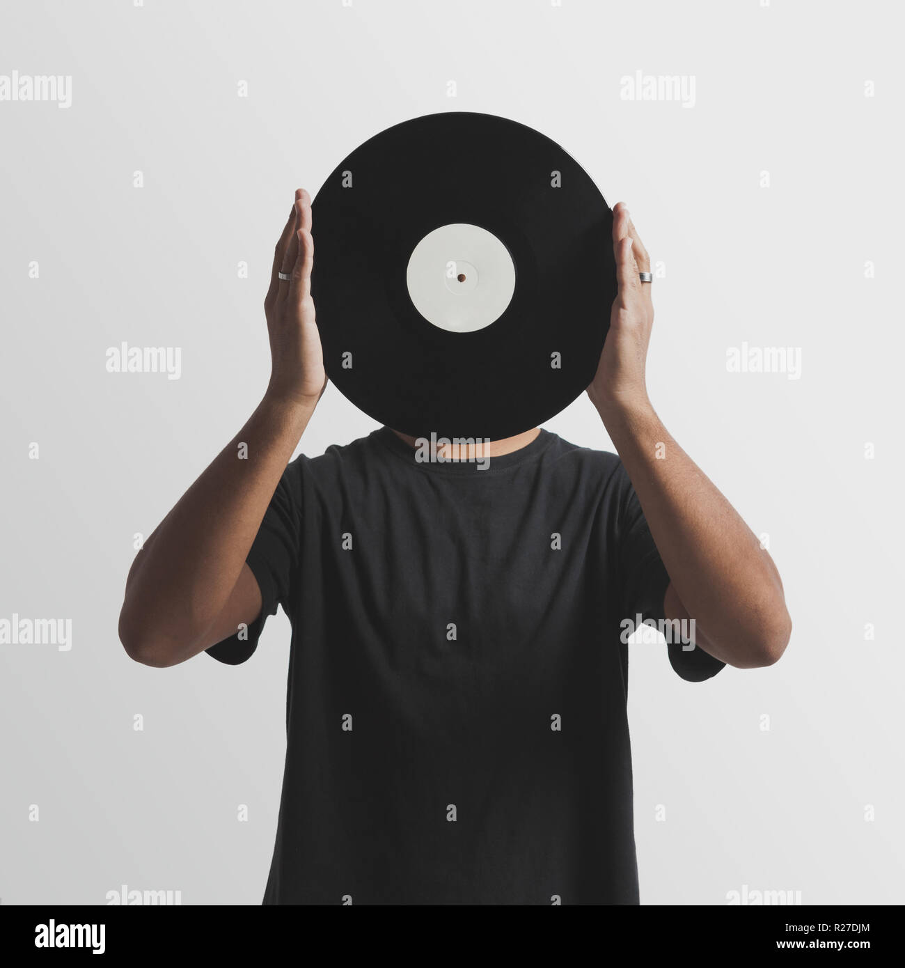 Young man olding a record in front of his face Stock Photo - Alamy
