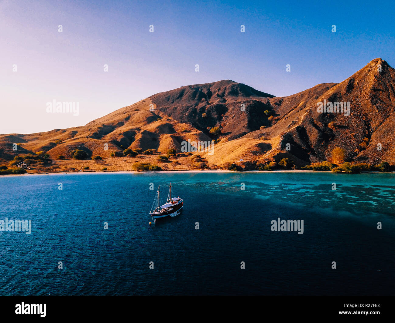 Diveboat in front of half burned Island in Indonesia, Komodo National ...