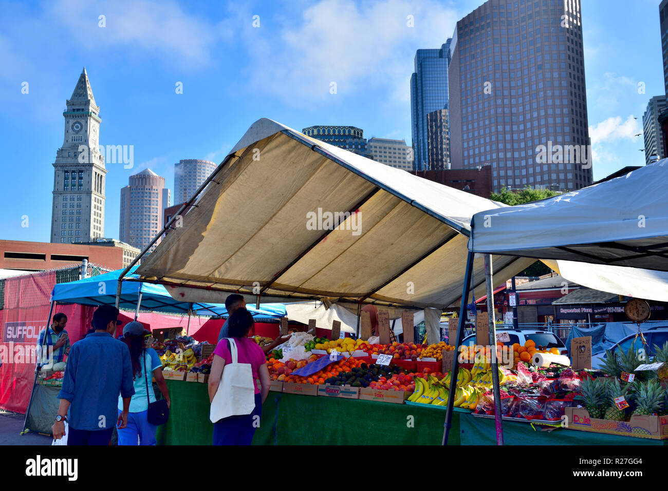 Boston street market with fresh vegetables and fruits and city skyline ...