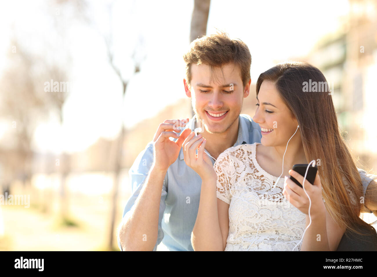 Couple sharing earbuds hi-res stock photography and images - Alamy