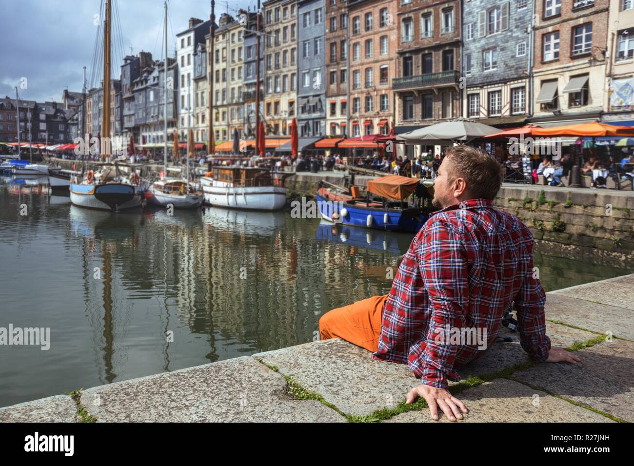 a man sitting on background famous French town of Honfleur. Normandy ...