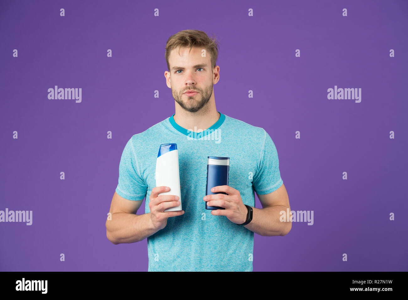 Make your choice. Man stylish hairstyle holds two bottles hygienic ...