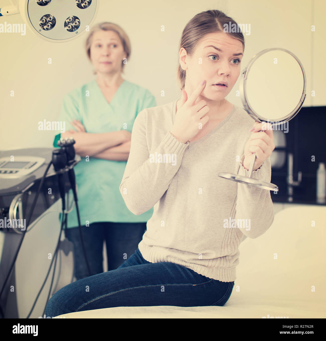 Young female patient unpleasantly surprised with results of cosmetic ...