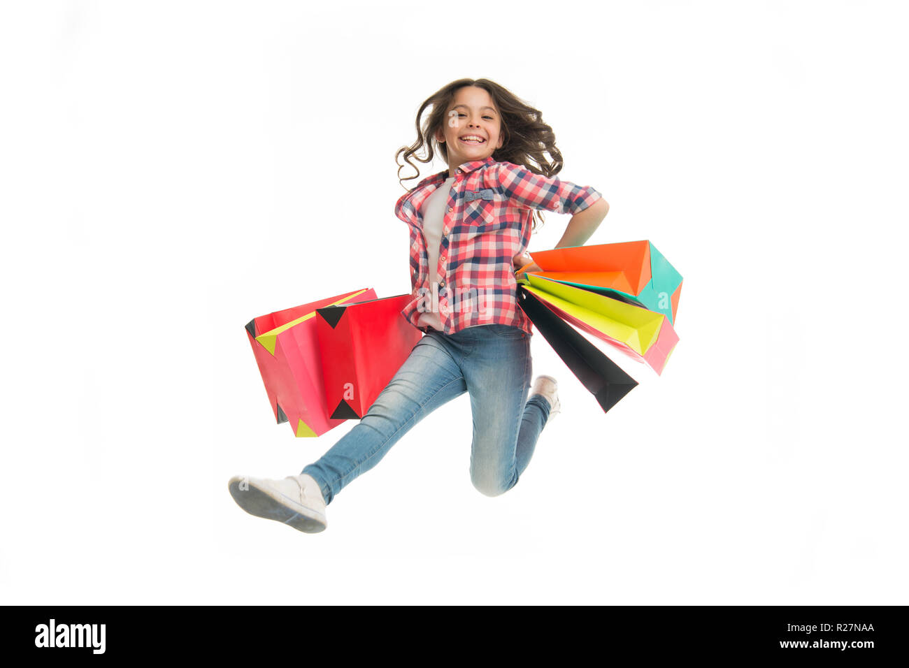 Happy girl jump with shopping bags isolated on white. Little shopaholic ...