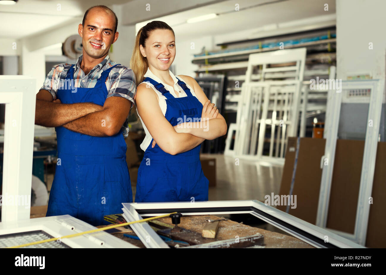 Portrait of two professional workers standing in assembly shop of ...