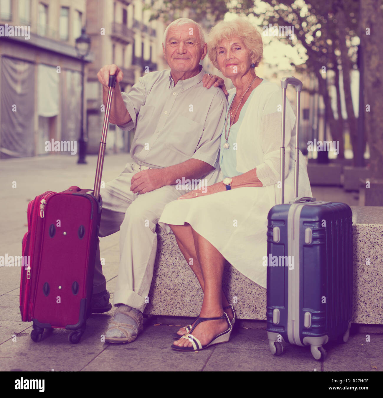 Happy loving aged spouses enjoying joint vacation sitting on bench with ...