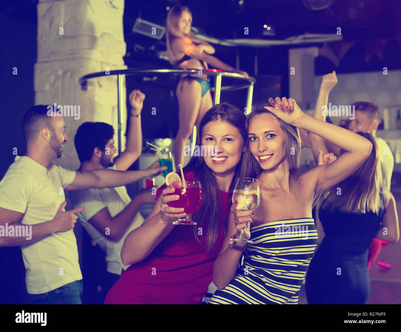Happy cheerful smiling females friends with cocktail dancing in the ...