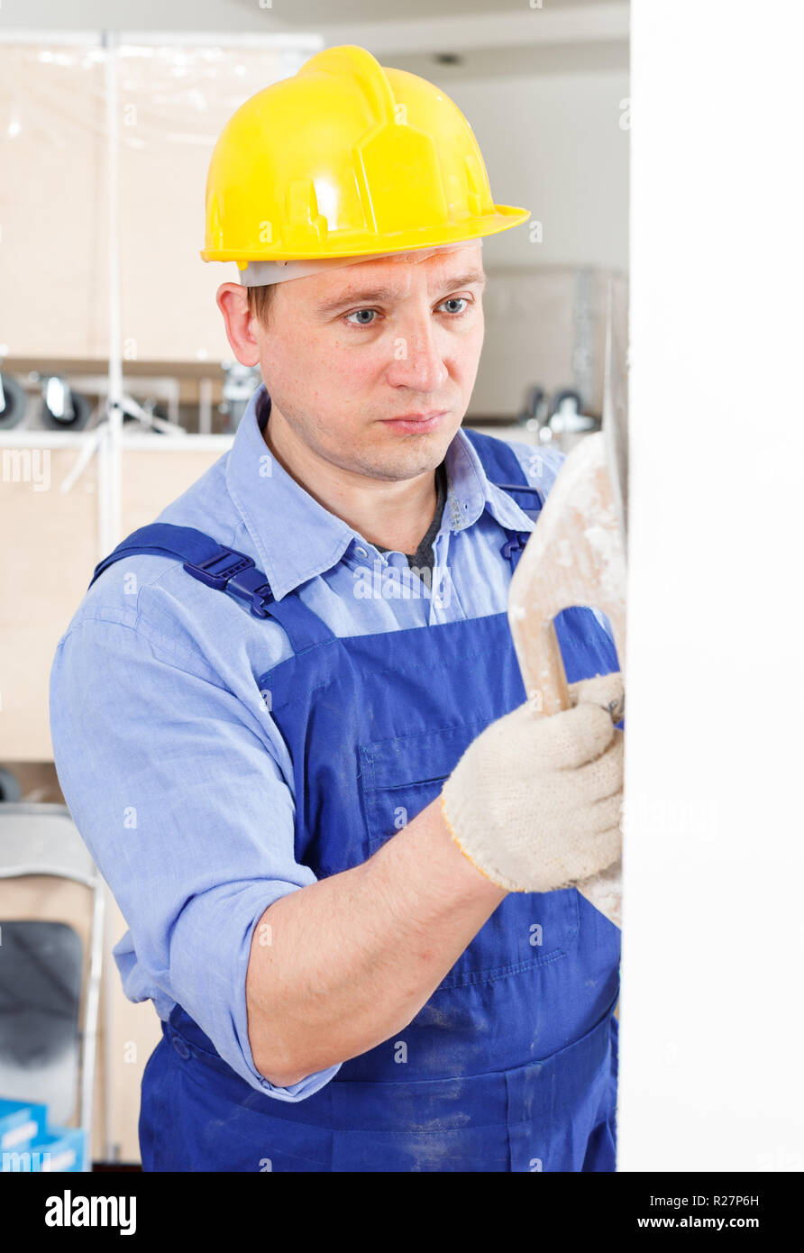 Confident male plasterer working at indoors building site, renovating ...