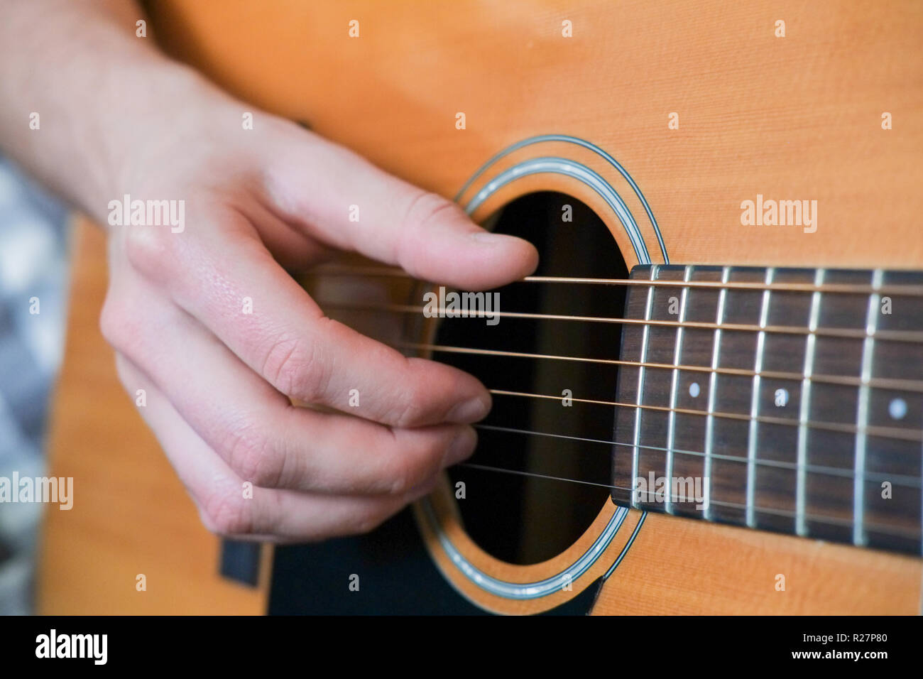 Male hand fingerpicking an acoustic guitar Stock Photo - Alamy