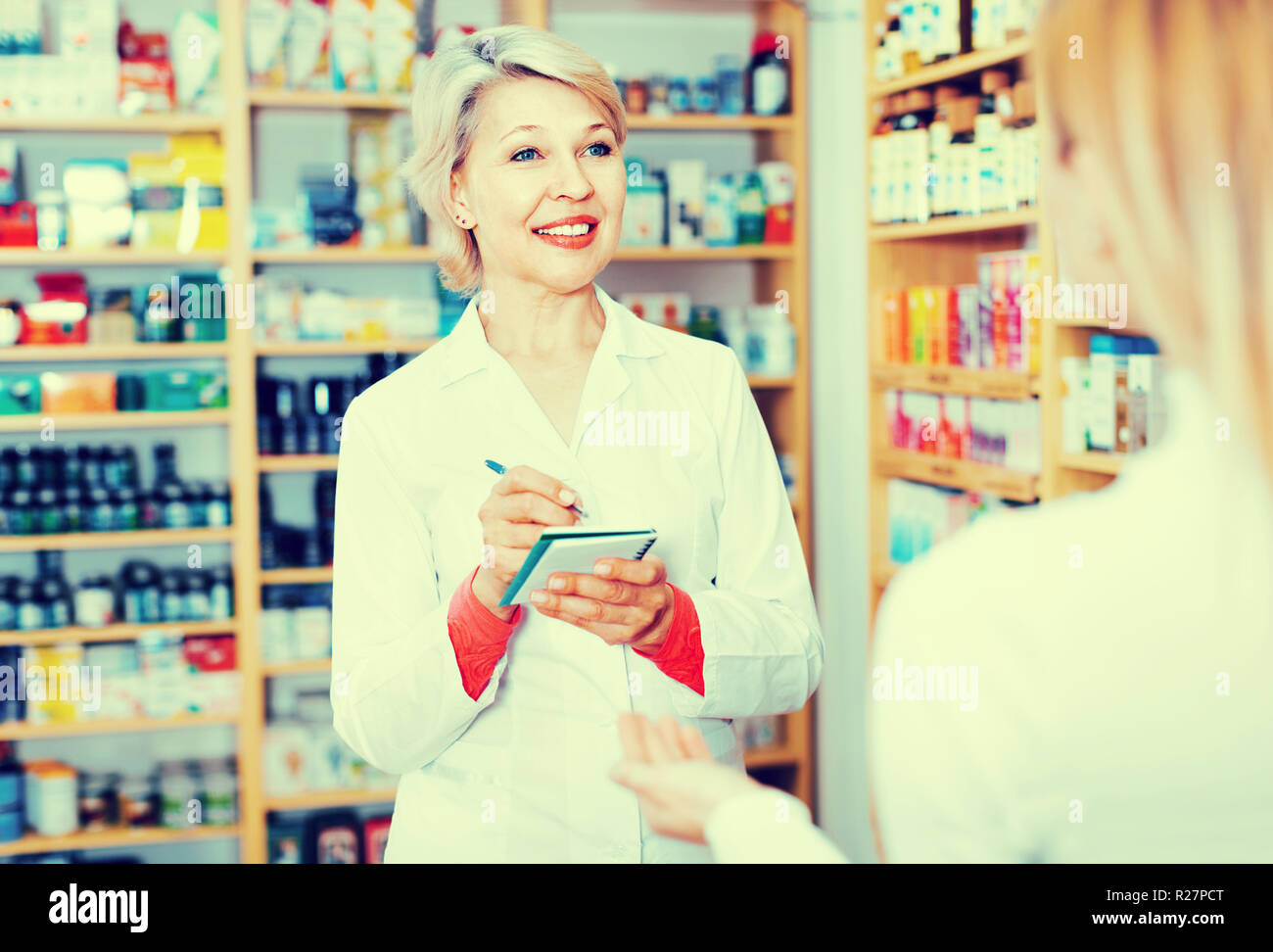 Glad cheerful positive smiling mature female seller suggesting care ...