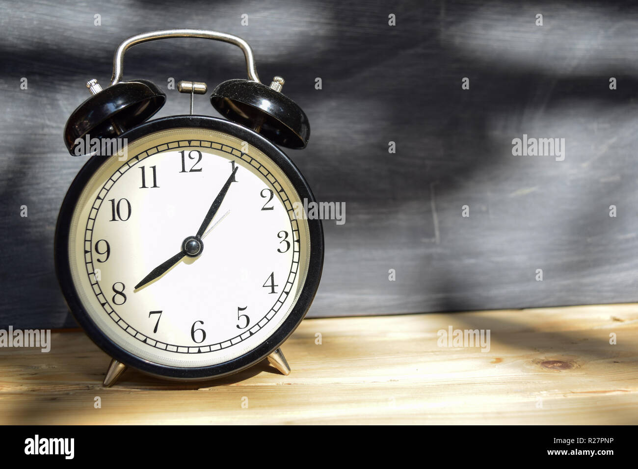 8 am/pm Back to school concept. Alarm clock on wooden with blackboard ...