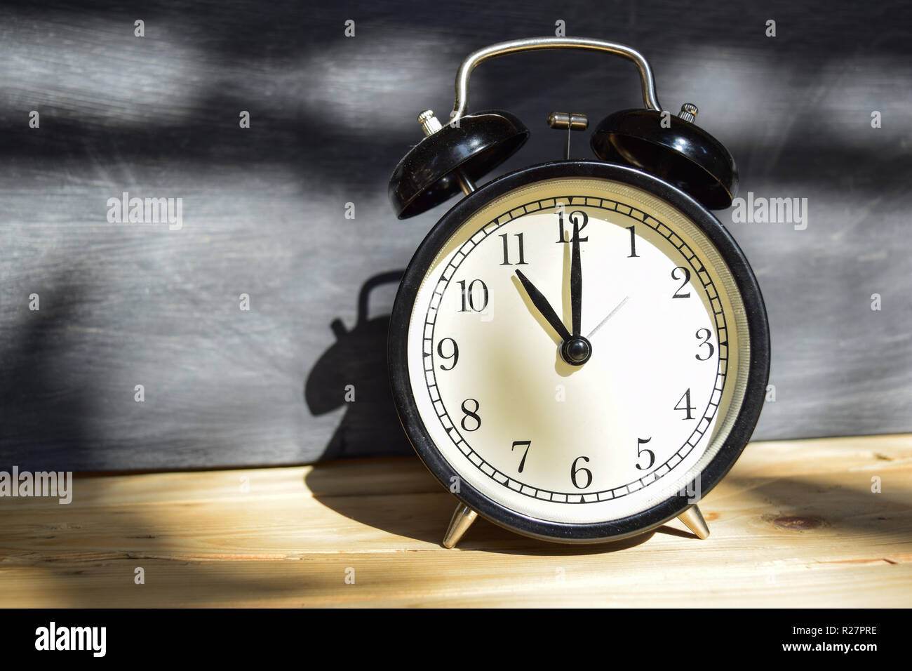 10 am/pm Back to school concept. Alarm clock on wooden with blackboard ...