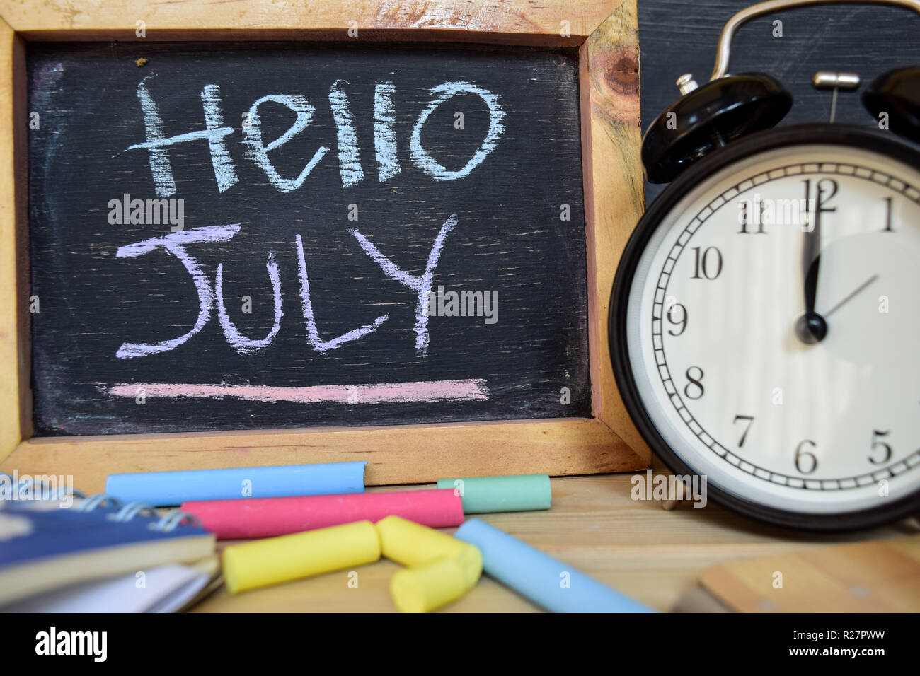 Hello july. Back to school concept. Alarm clock on wooden with ...