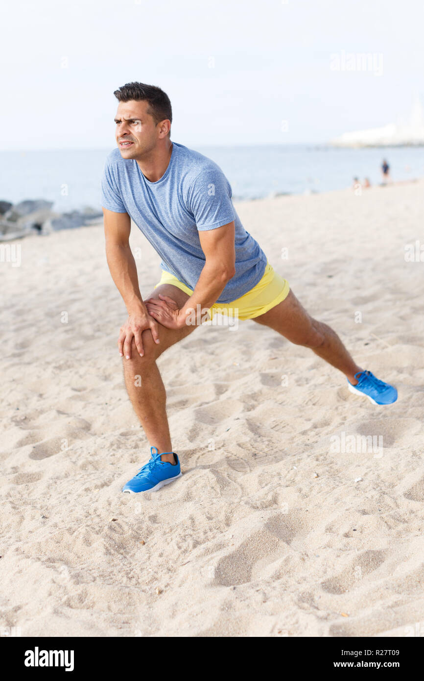 Portrait of young fit man exercising during morning workout on sunny ...