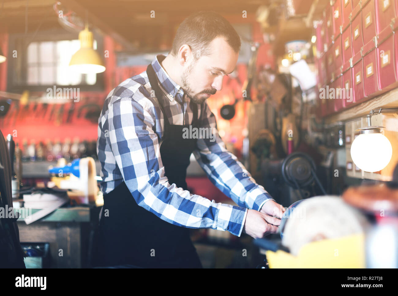 Male worker polishing buckle for belt in leather workshop Stock Photo ...