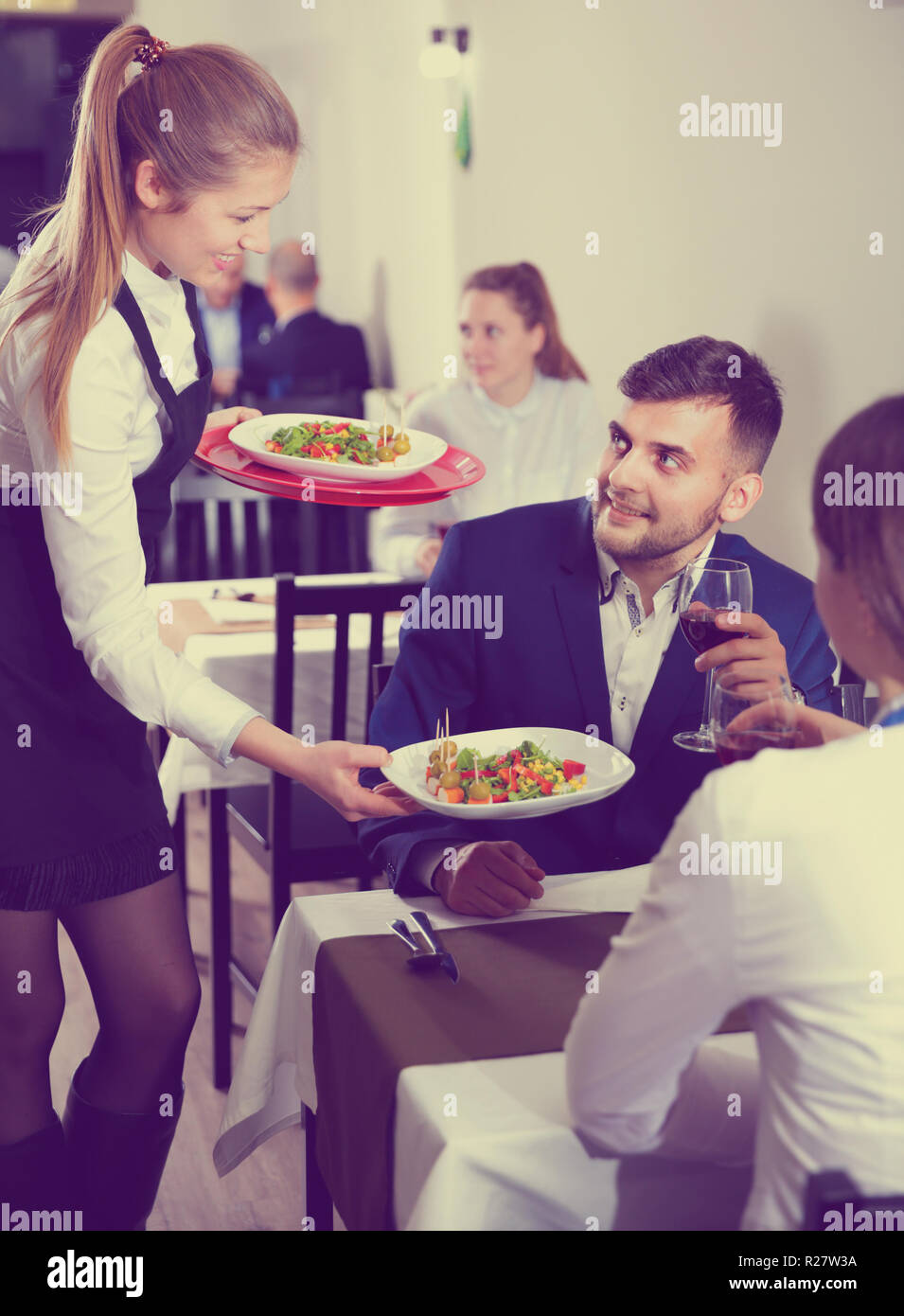 Woman waiter is giving dish to client in restaurante indoor Stock Photo ...