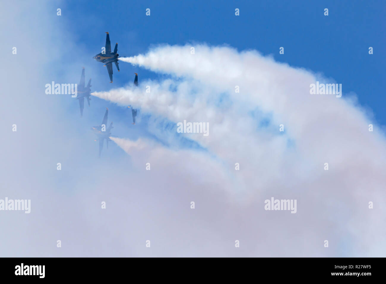 The Blue Angels diamond formation performs a rolling maneuver leaving a ...