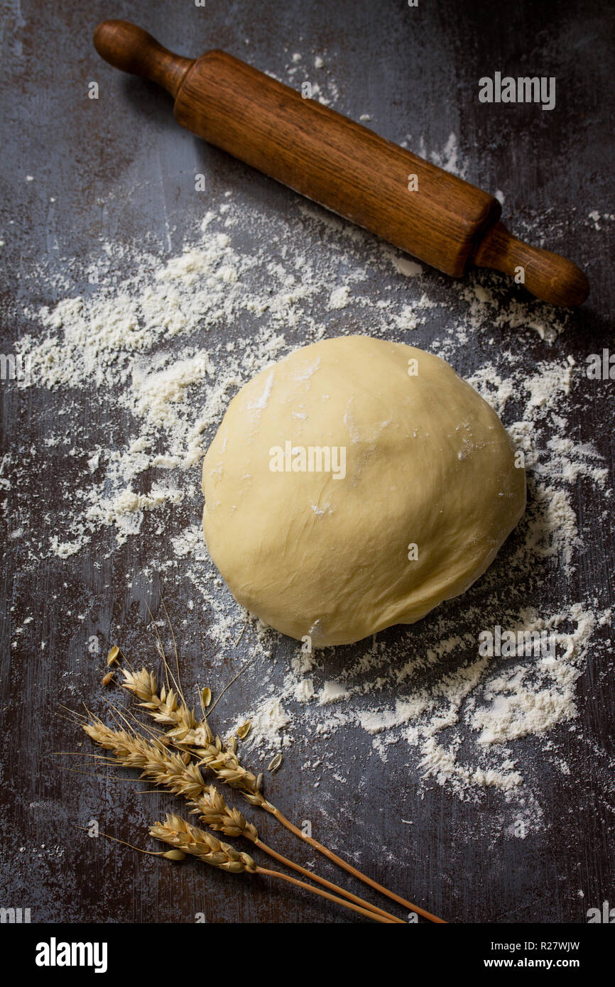 Dough. Fresh raw dough ball for bread or pizza on a dark table, baking ...