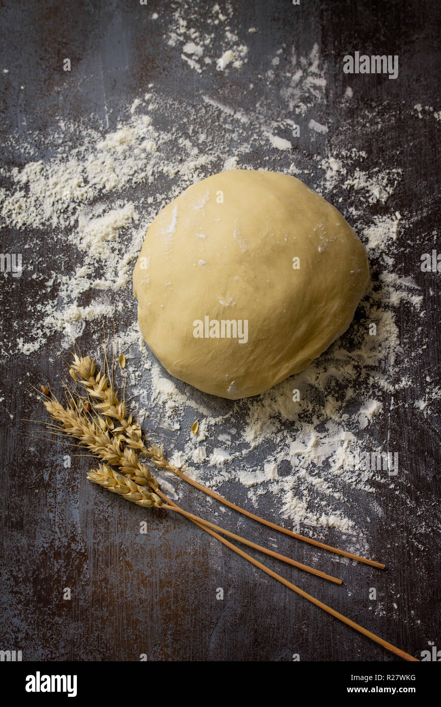Dough. Fresh raw dough ball for bread or pizza on a dark table, baking ...