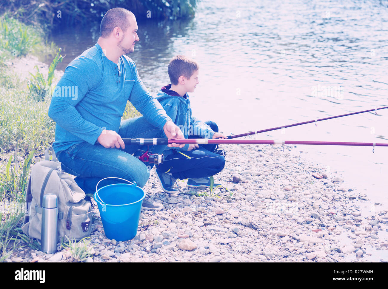 Happy man and glad boy spending time outdoors and fishing Stock Photo ...