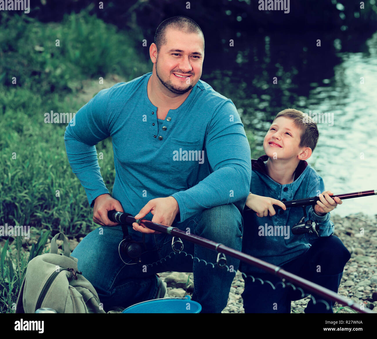 Laughing father and boy fishing with rods in summer day Stock Photo - Alamy