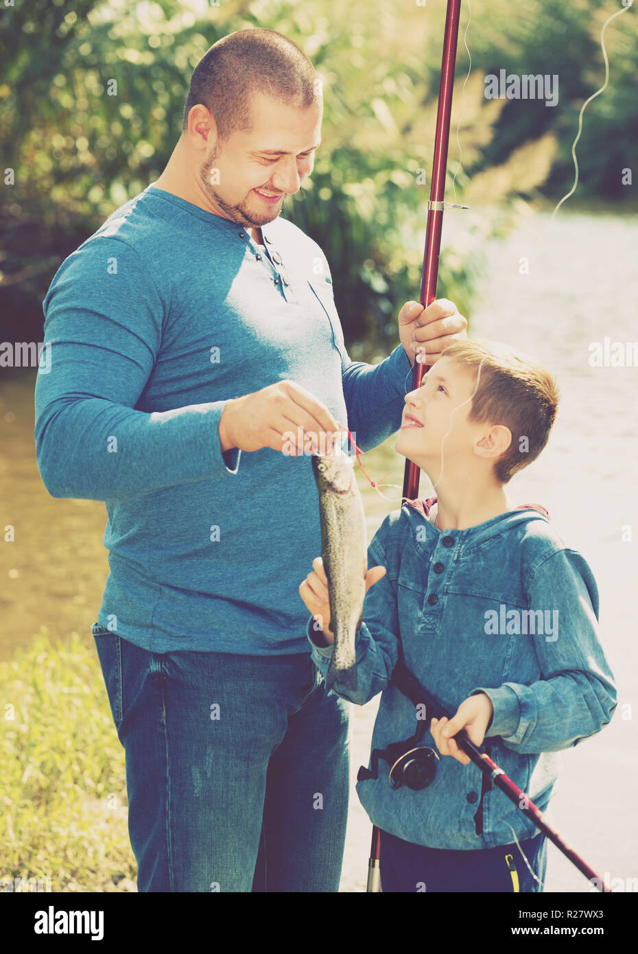 Happy adult man and glad boy spending time outdoors and fishing Stock ...