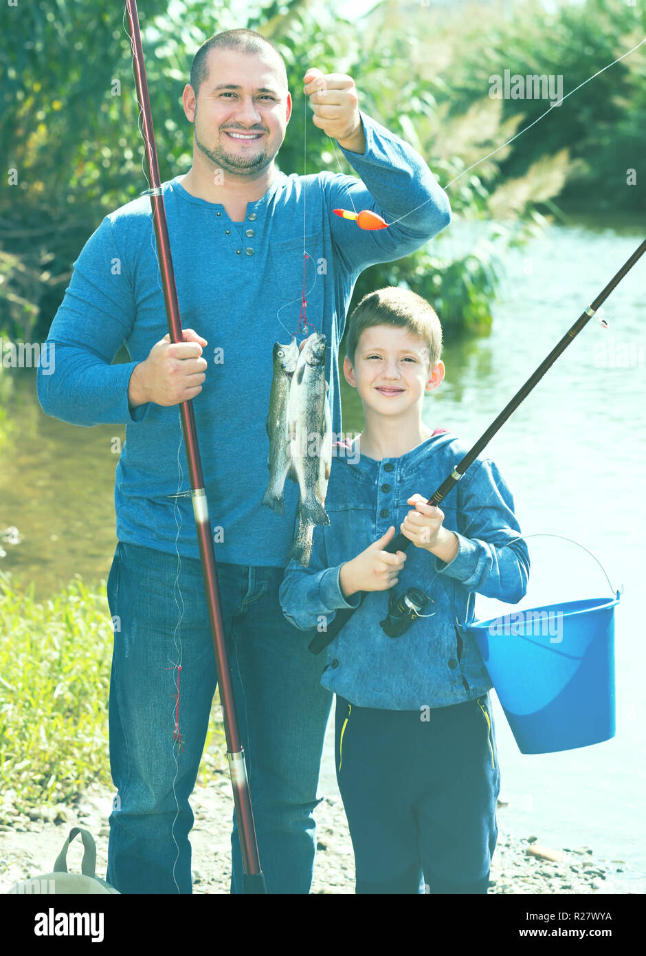 Happy father and son fishing with rods in summer day Stock Photo - Alamy