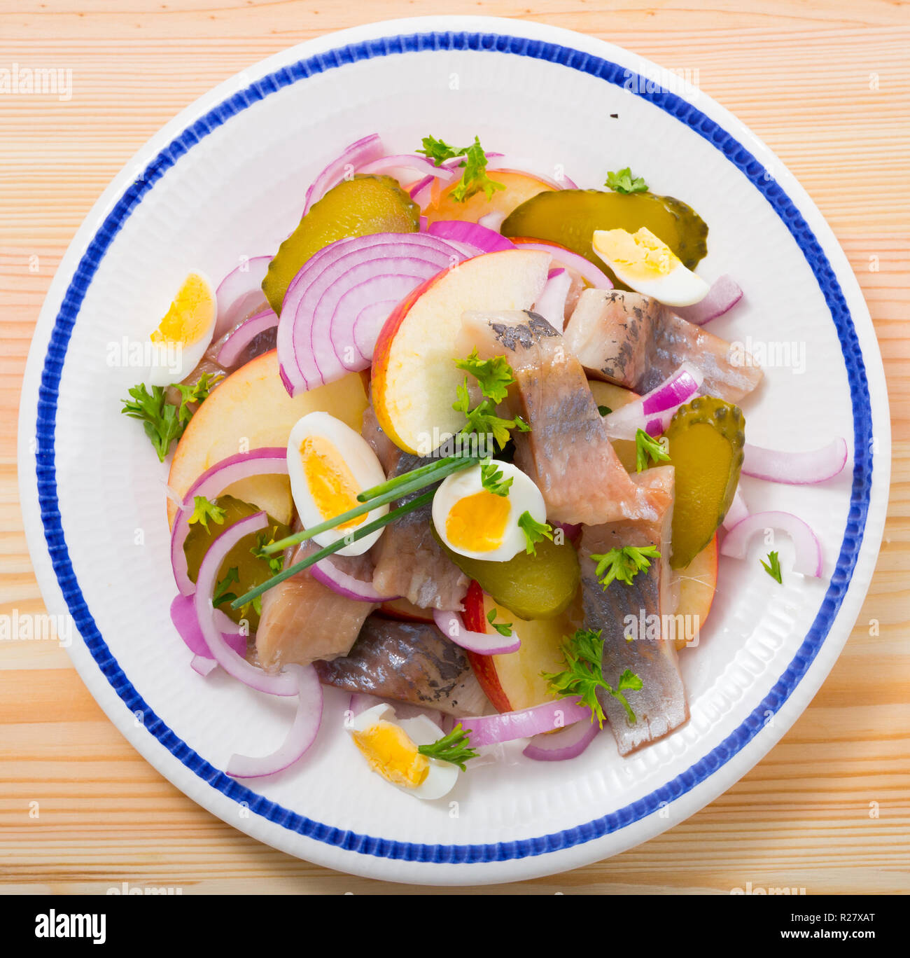 Top view of Norwegian salad of marinated herring with fresh apples ...