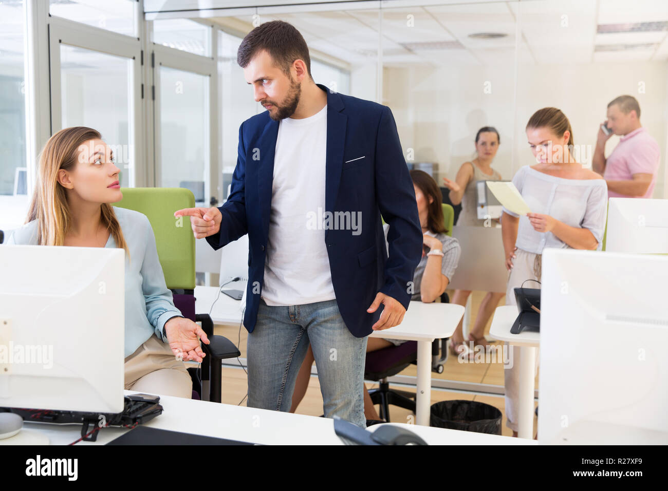 Irritated adult boss scolding female subordinate pointing out ...