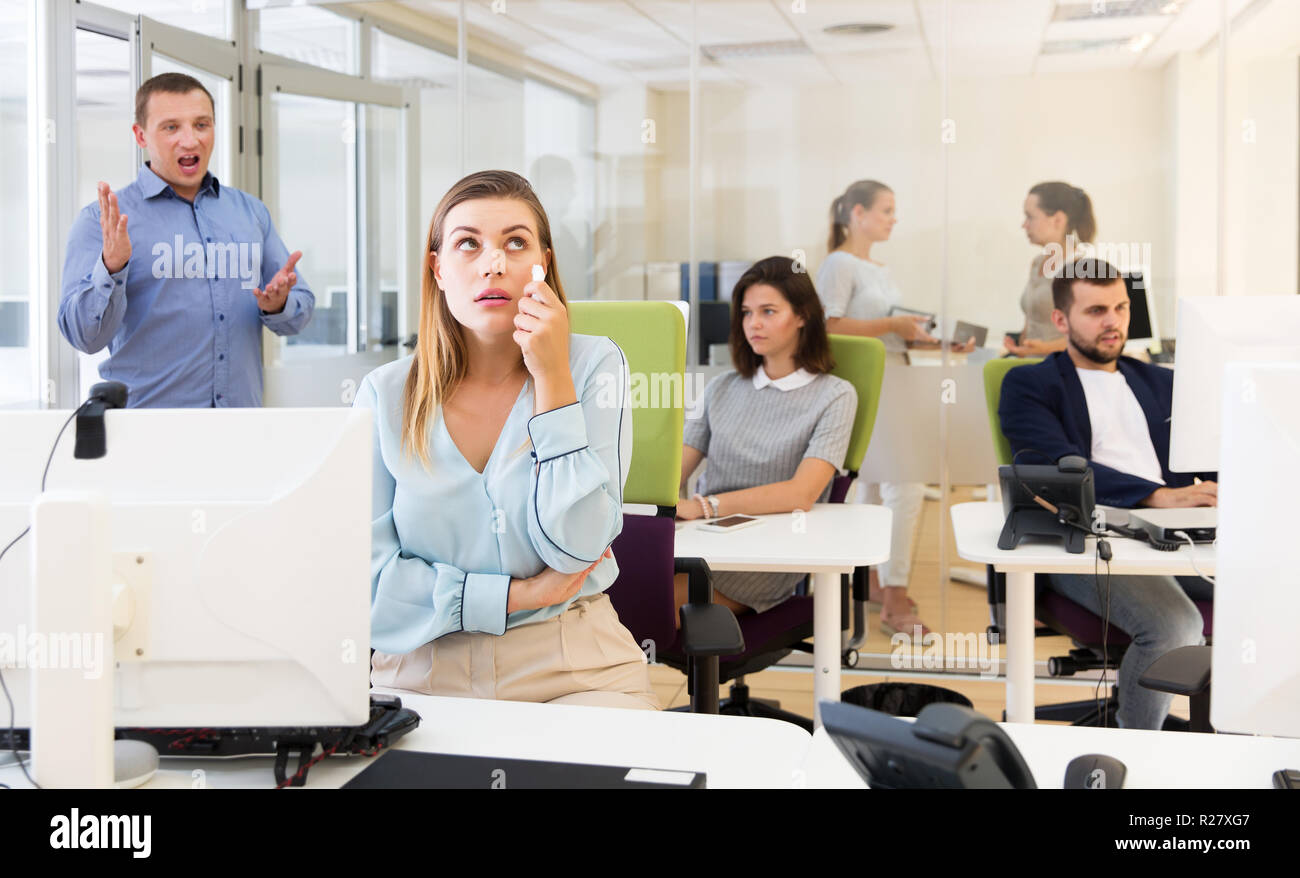 Irritated young boss scolding unhappy female subordinate pointing out ...