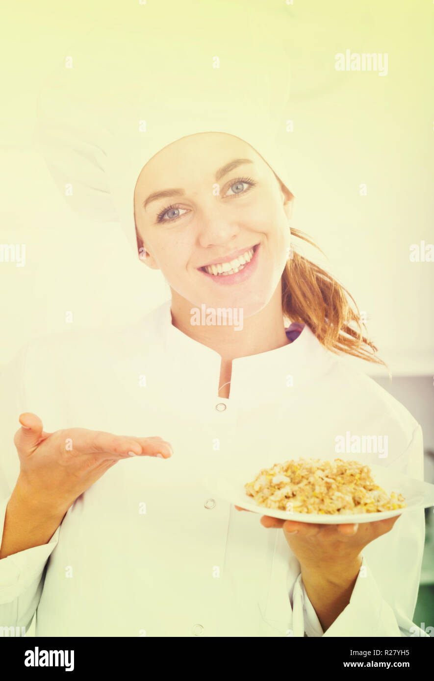 smiling girl cook with chestnut hair shows plate of porrige Stock Photo ...