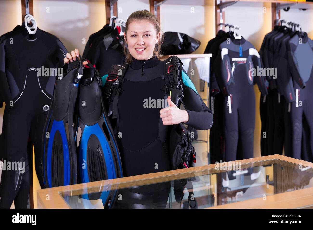 Female is standing in full set of modern diving equipment in the store ...